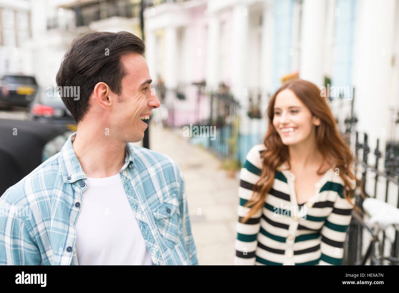 Couple in street face to face smiling Stock Photo - Alamy