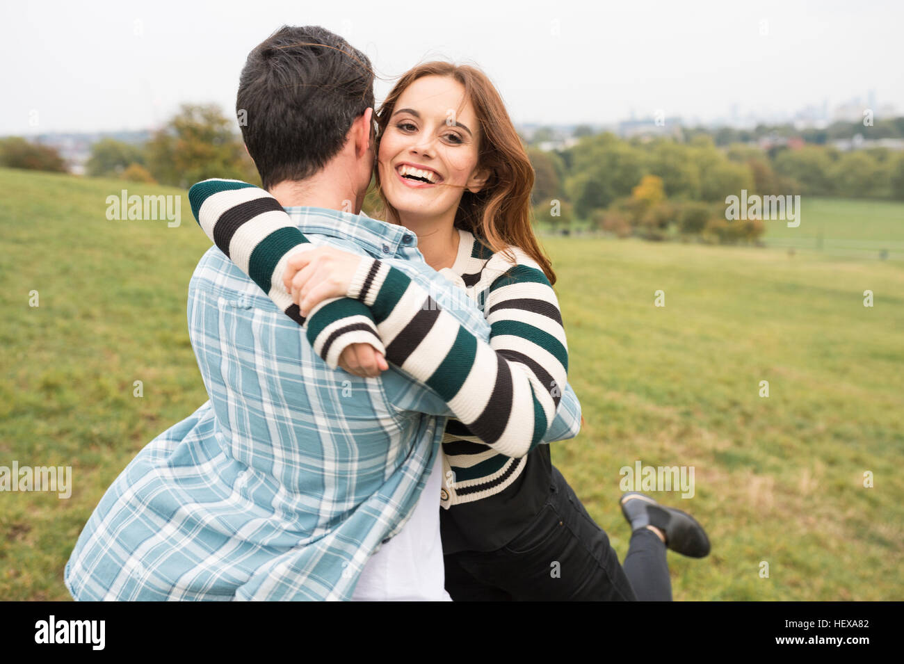 Couple hugging in field Stock Photo - Alamy