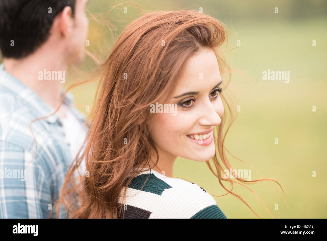 Portrait of woman looking over shoulder smiling Stock Photo - Alamy