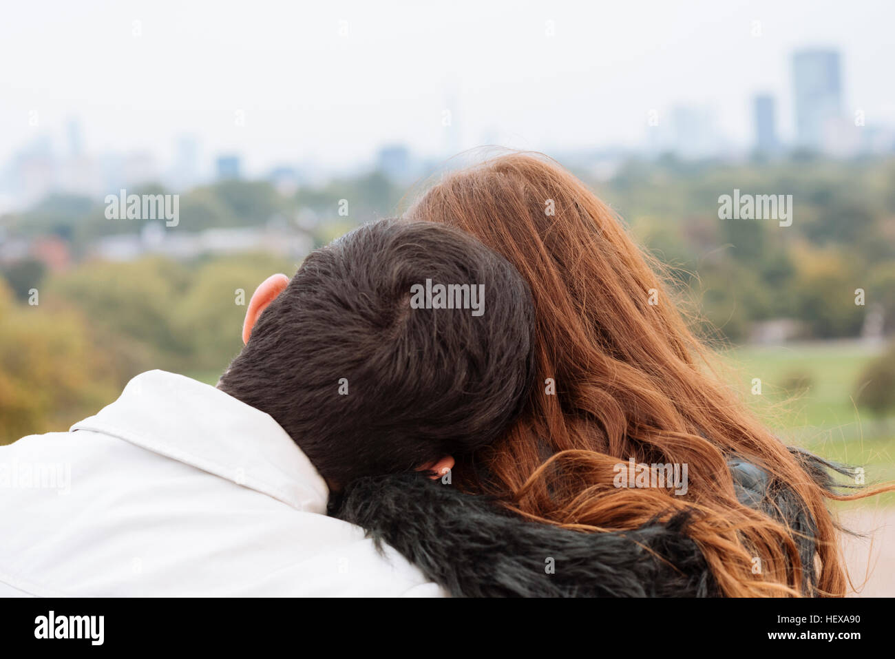 Rear view of couple head to head hugging Stock Photo - Alamy