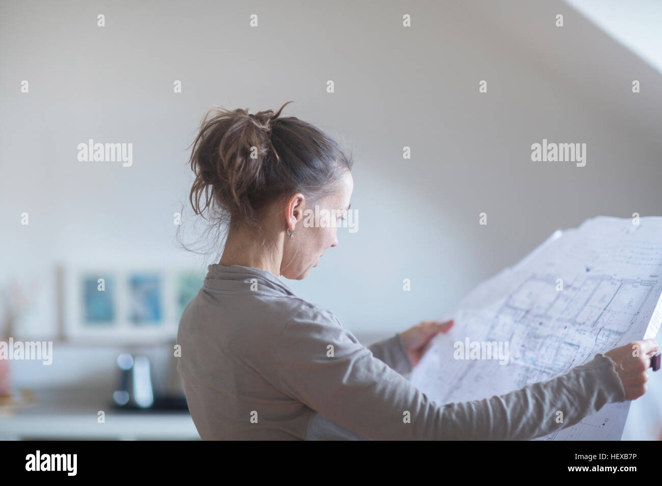 Mature woman looking at blueprints Stock Photo - Alamy