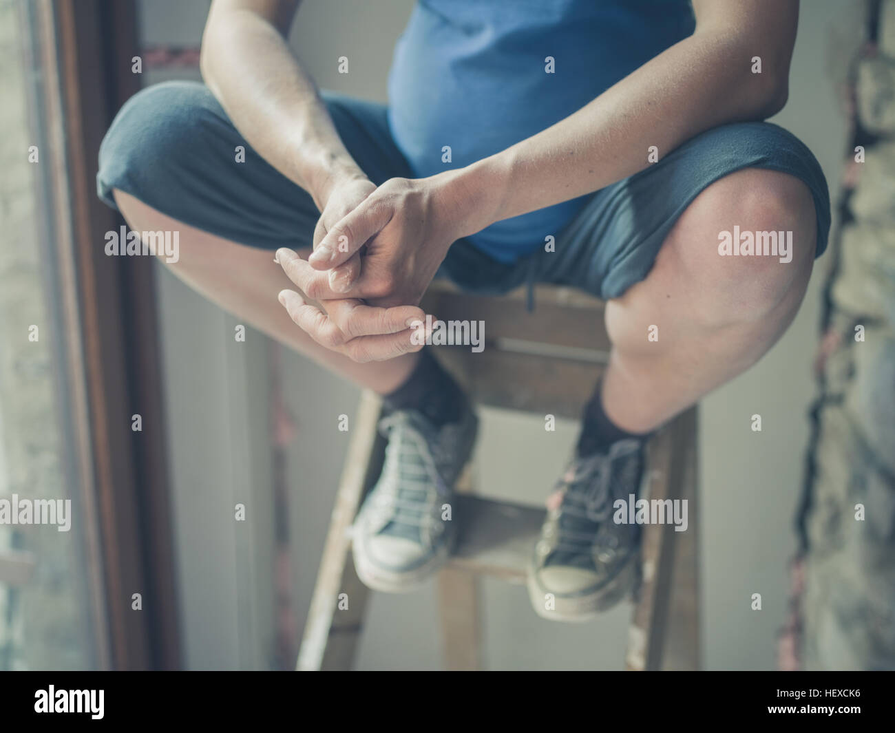 A young pregnant woman is sitting on a step ladder Stock Photo - Alamy
