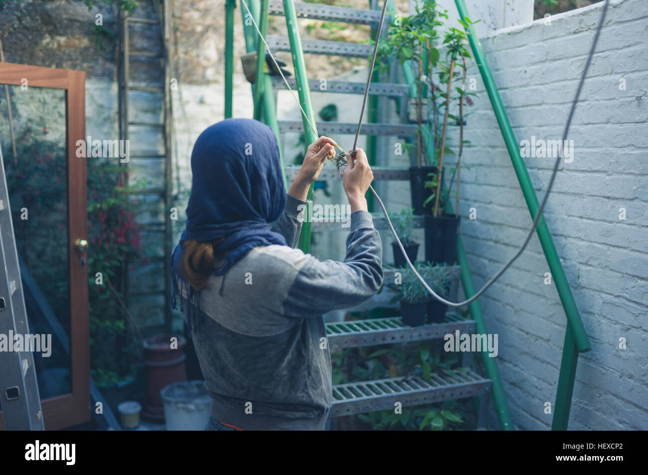 A young woman is fixing her washing line in the courtyard Stock Photo ...