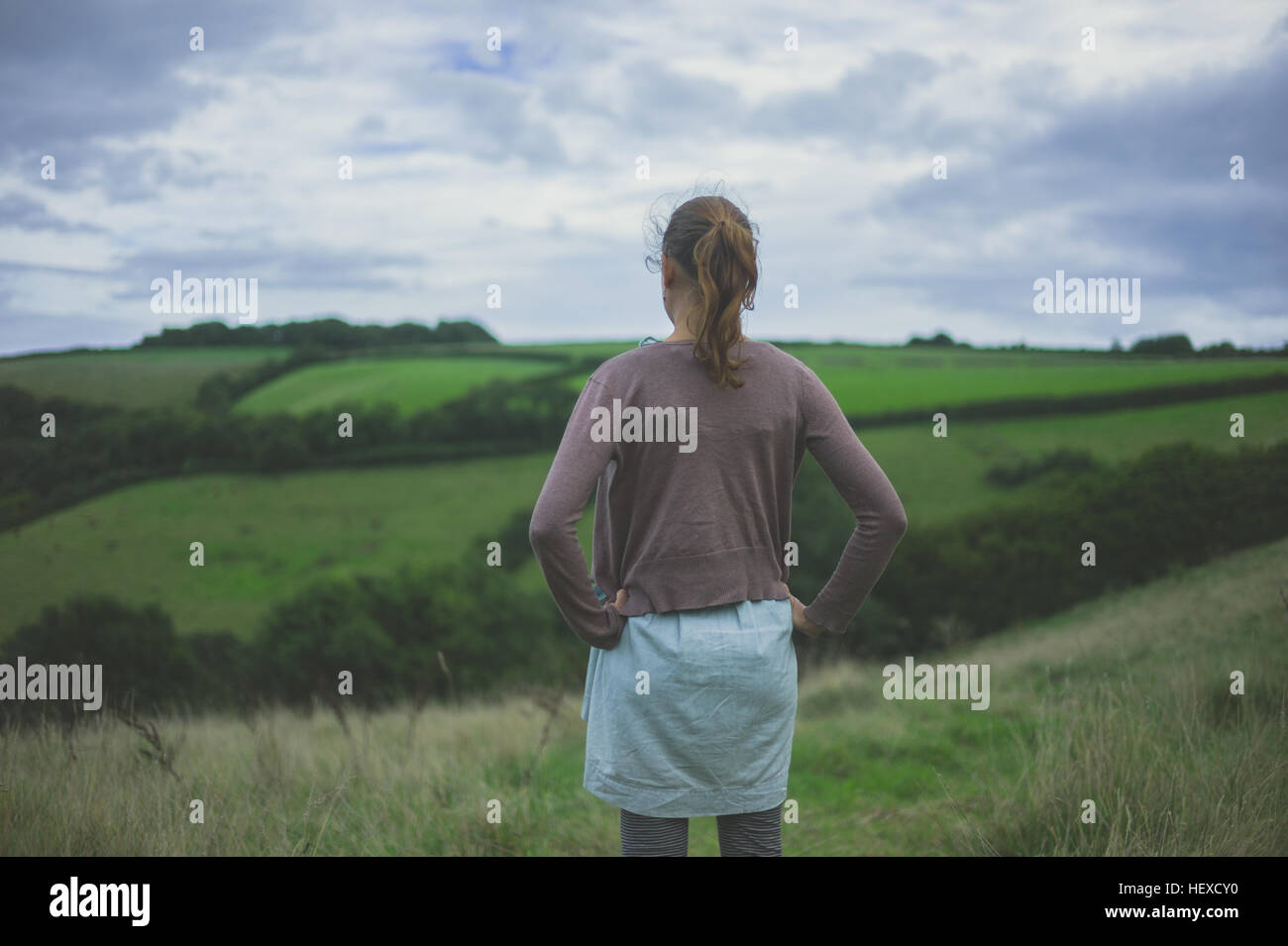 A young woman is standing in the countryside Stock Photo - Alamy
