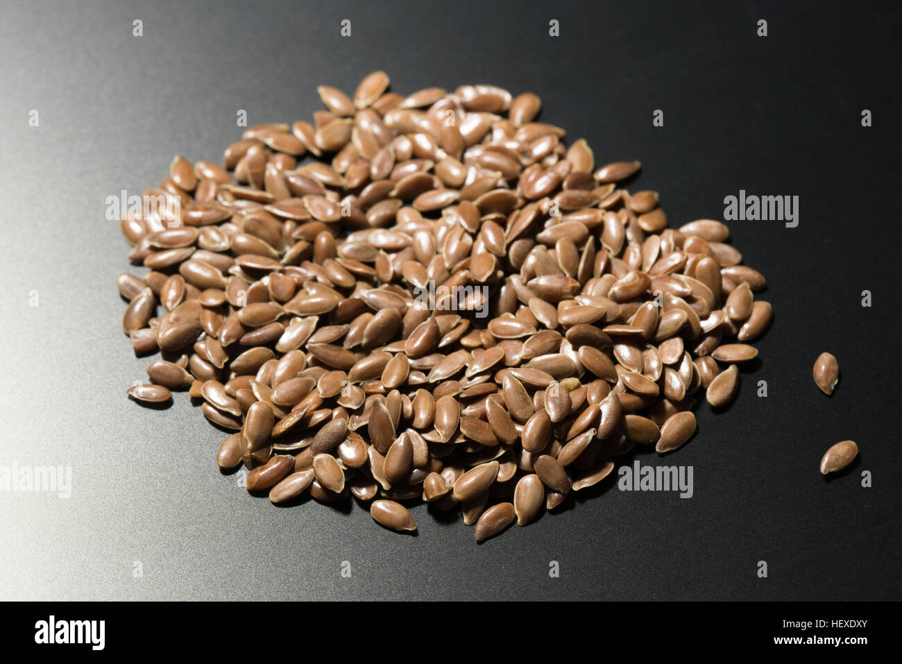 Flax seeds against a black background Stock Photo - Alamy