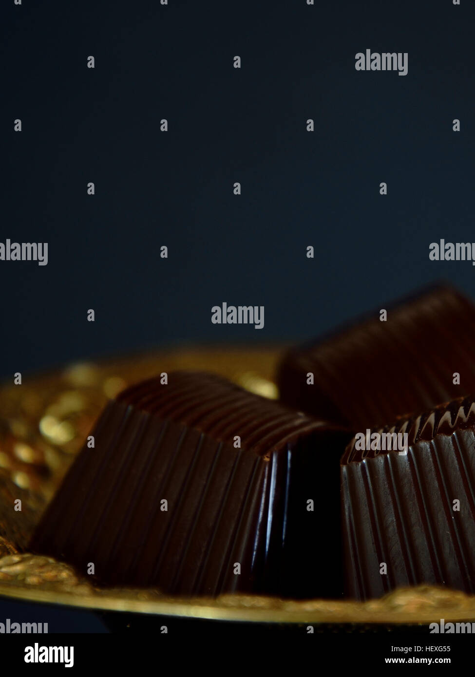 Three chocolates in golden plate Stock Photo - Alamy