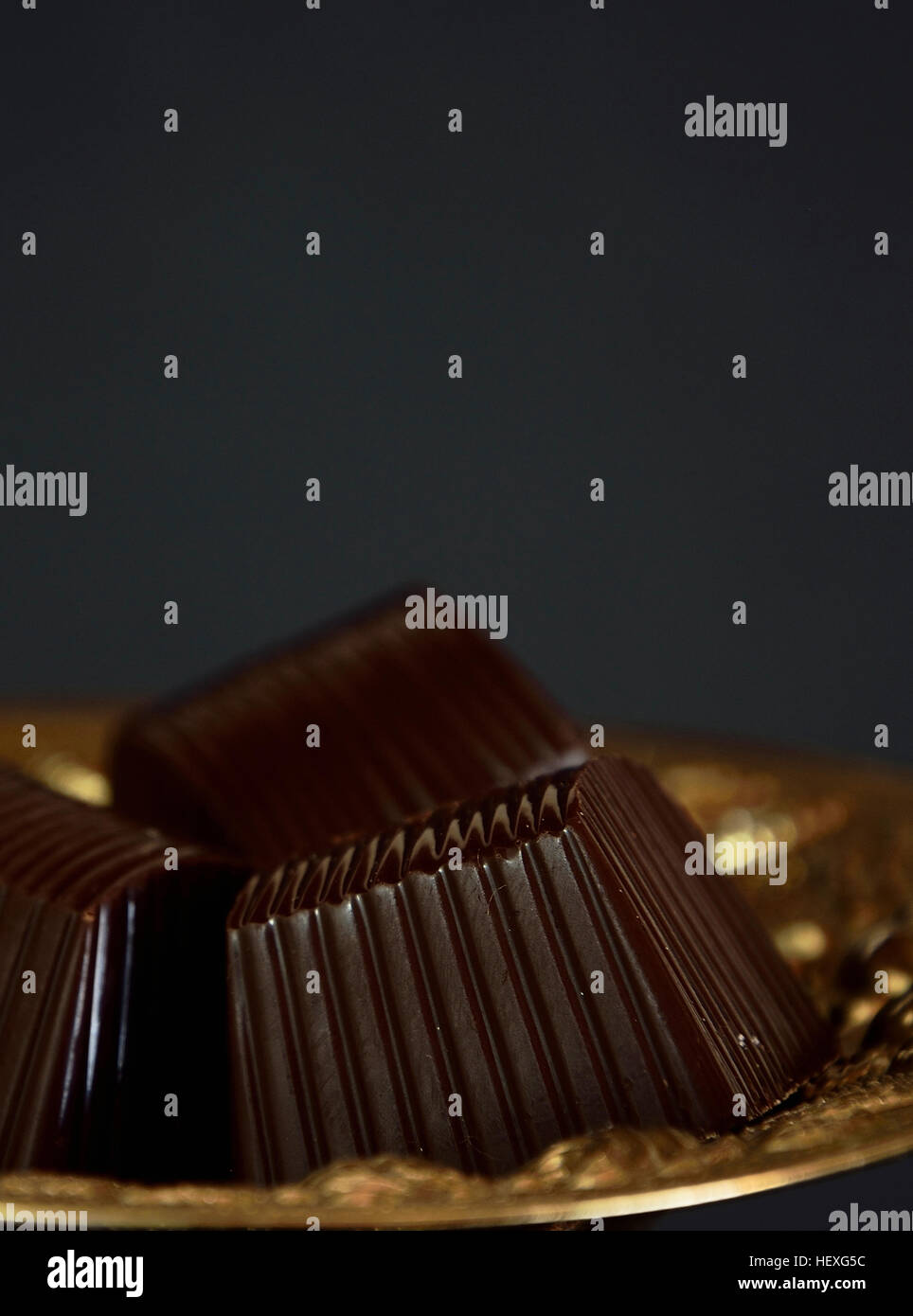 Three chocolates in golden plate Stock Photo - Alamy