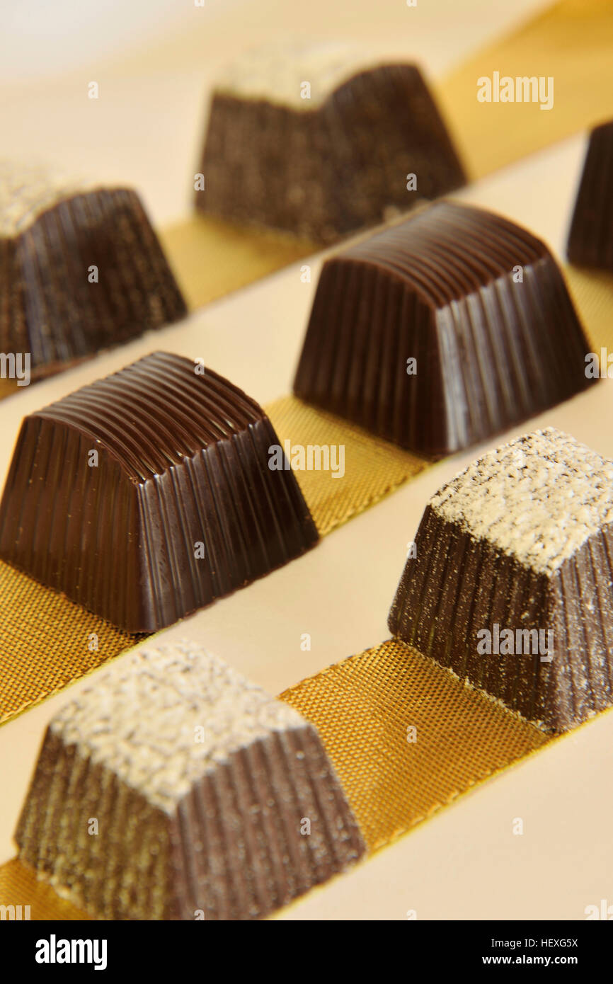 Chocolates in Golden row Stock Photo - Alamy