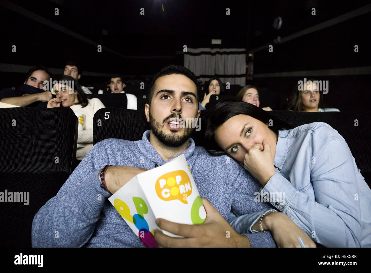 Scared couple watching a movie in a cinema Stock Photo - Alamy