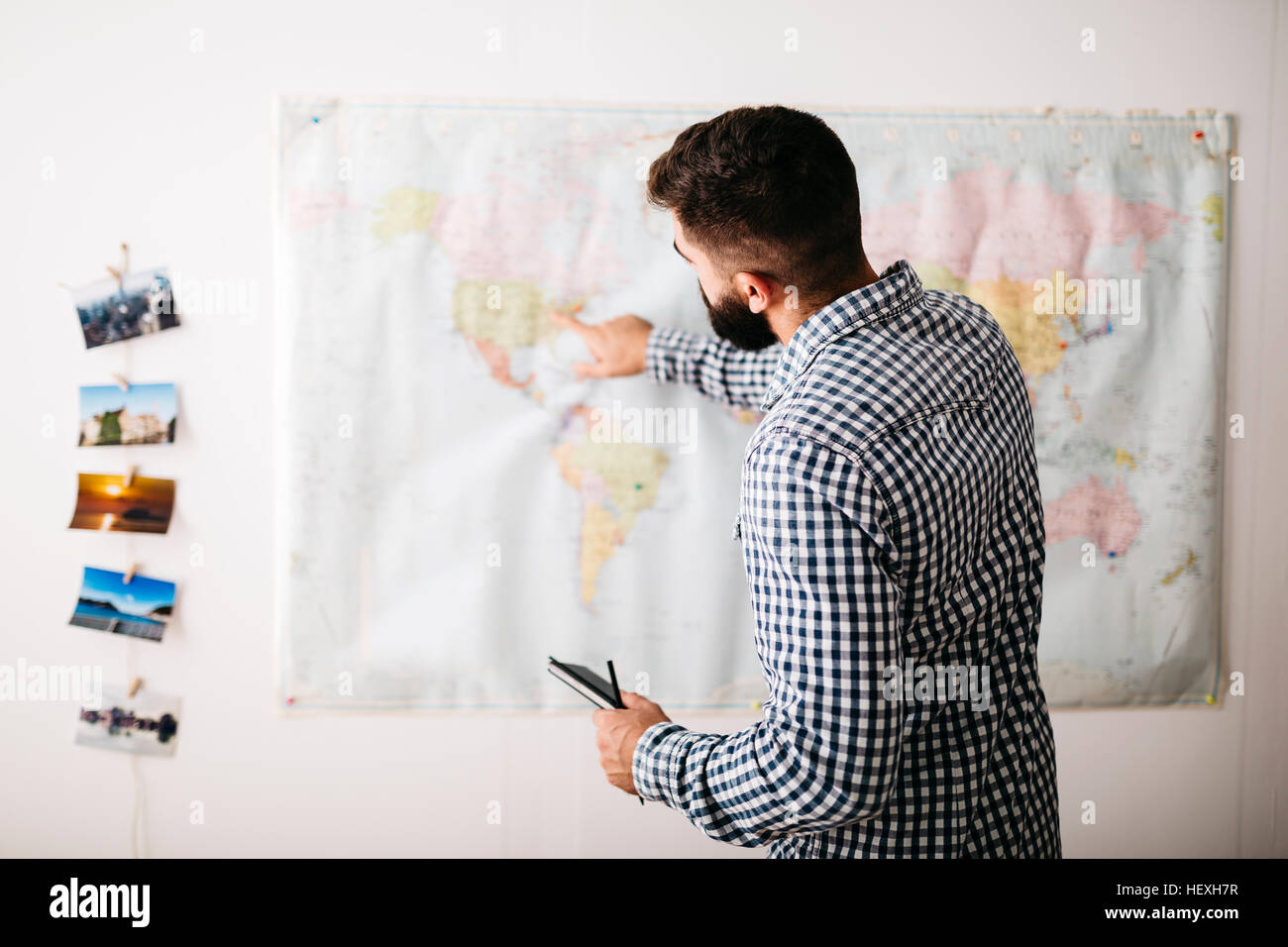 Young man selecting travel destinations on a world map Stock Photo - Alamy