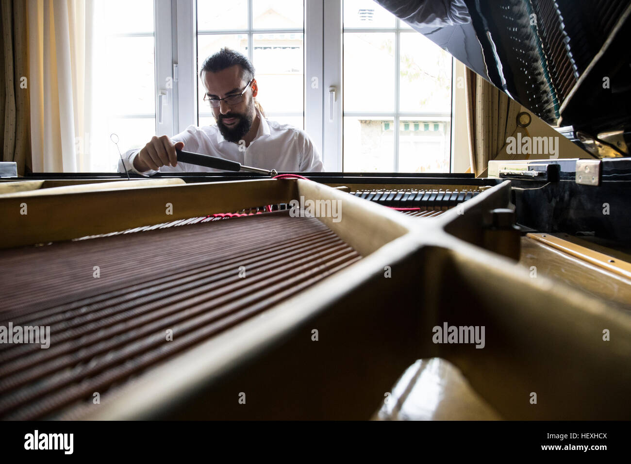 Piano tuner tuning grand piano Stock Photo - Alamy