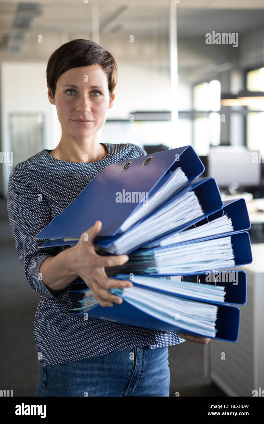 Businesswoman in office holding folders Stock Photo - Alamy