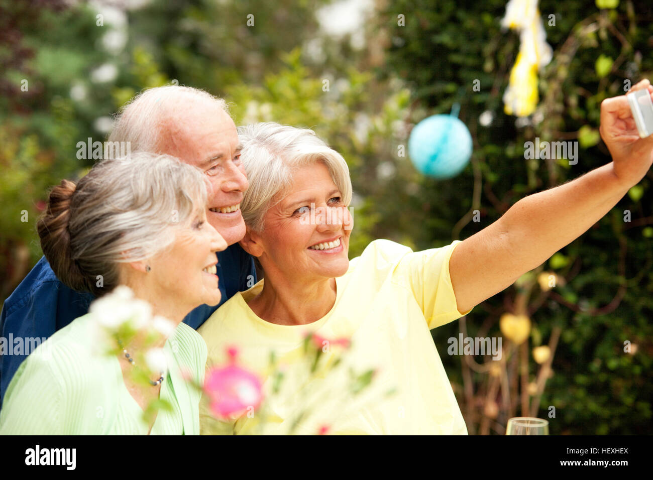 Senior man taking selfie with guests Stock Photo - Alamy