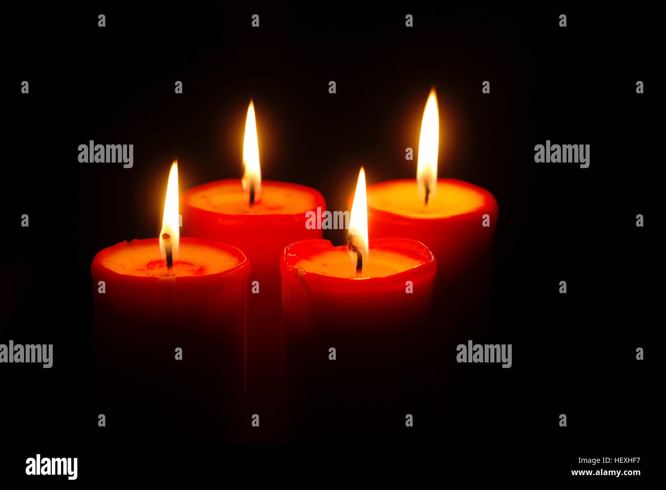 Four lighted red candles Stock Photo - Alamy