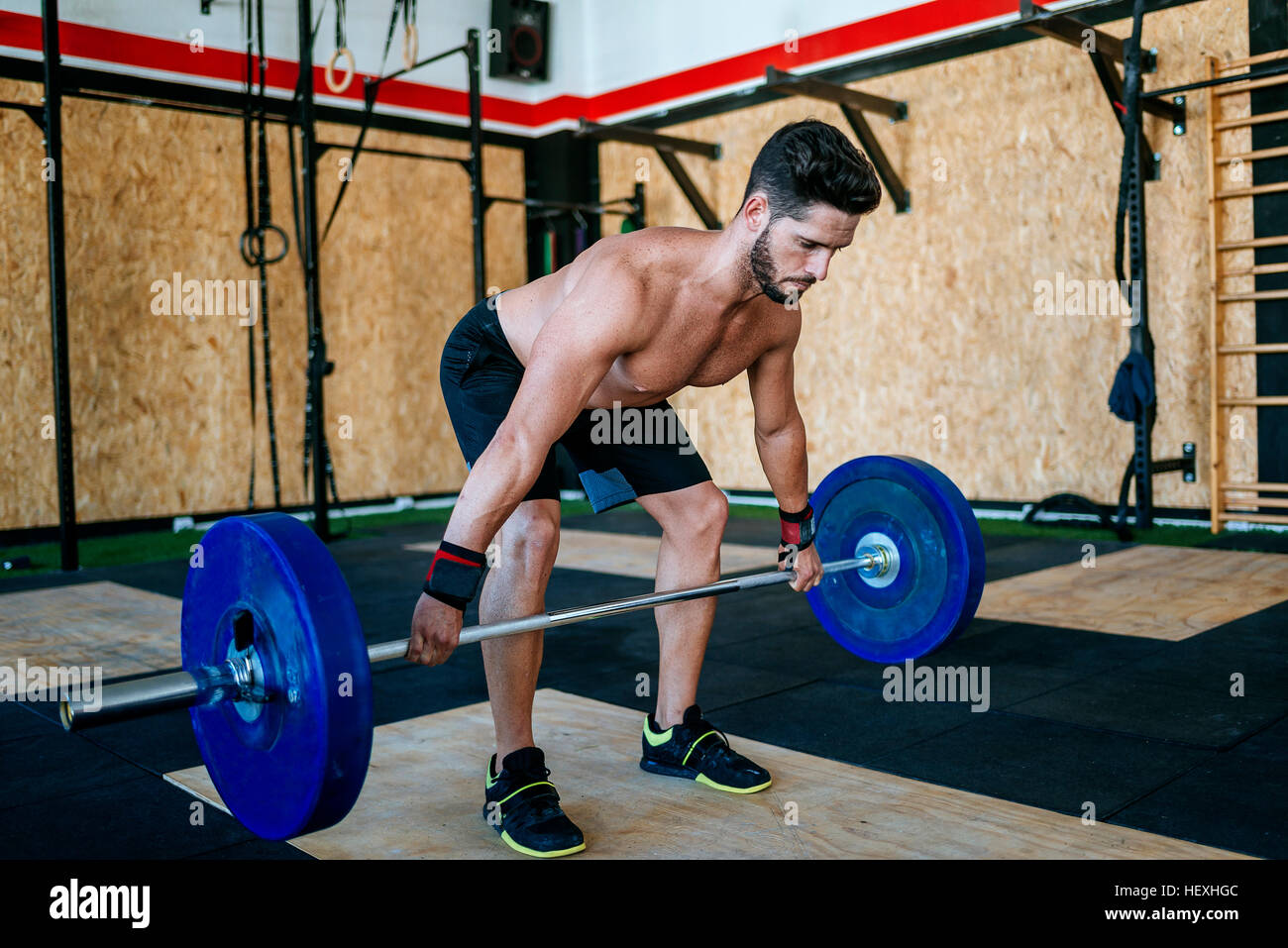 Man lifting barbell in gym Stock Photo - Alamy