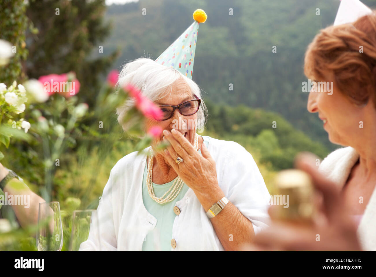 Senior ladies laughing at celebration, wearing party hats Stock Photo ...