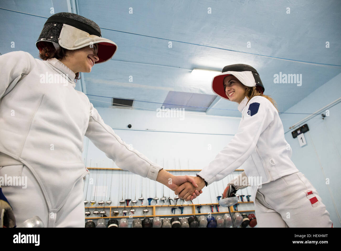 Female fencers shaking hands after a fencing match Stock Photo - Alamy