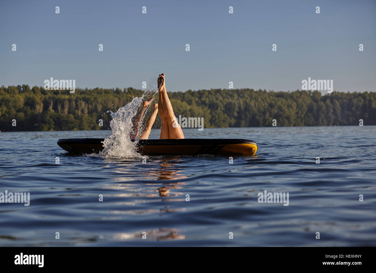 Two women jumping into water from paddleboard Stock Photo - Alamy