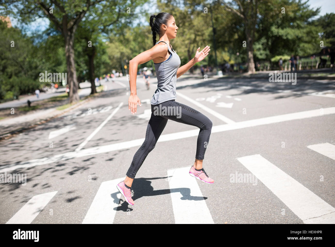 Woman running on zebra crossing Stock Photo - Alamy
