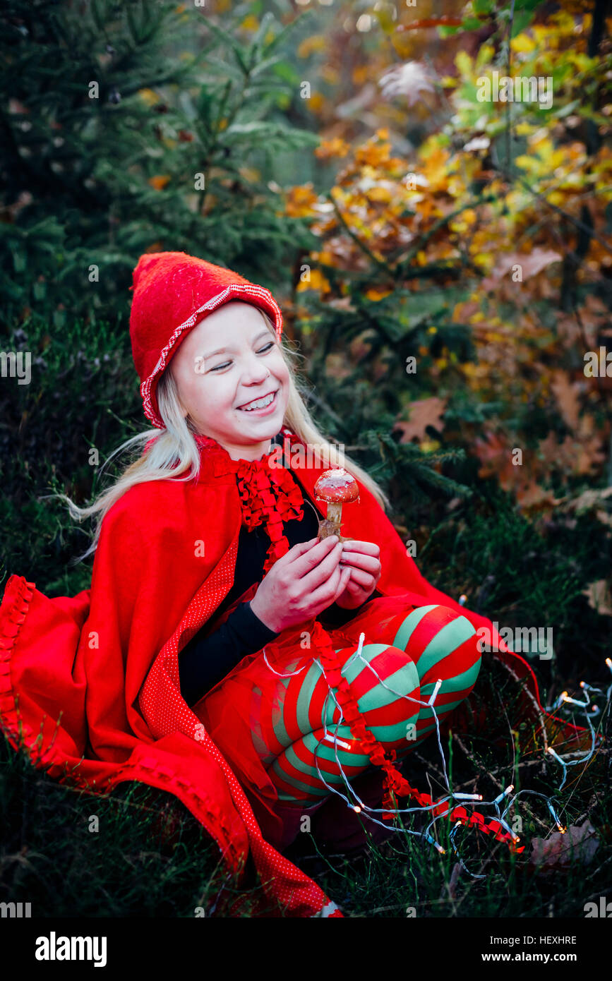 Little imp sitting in forest, holding fly agaric Stock Photo - Alamy