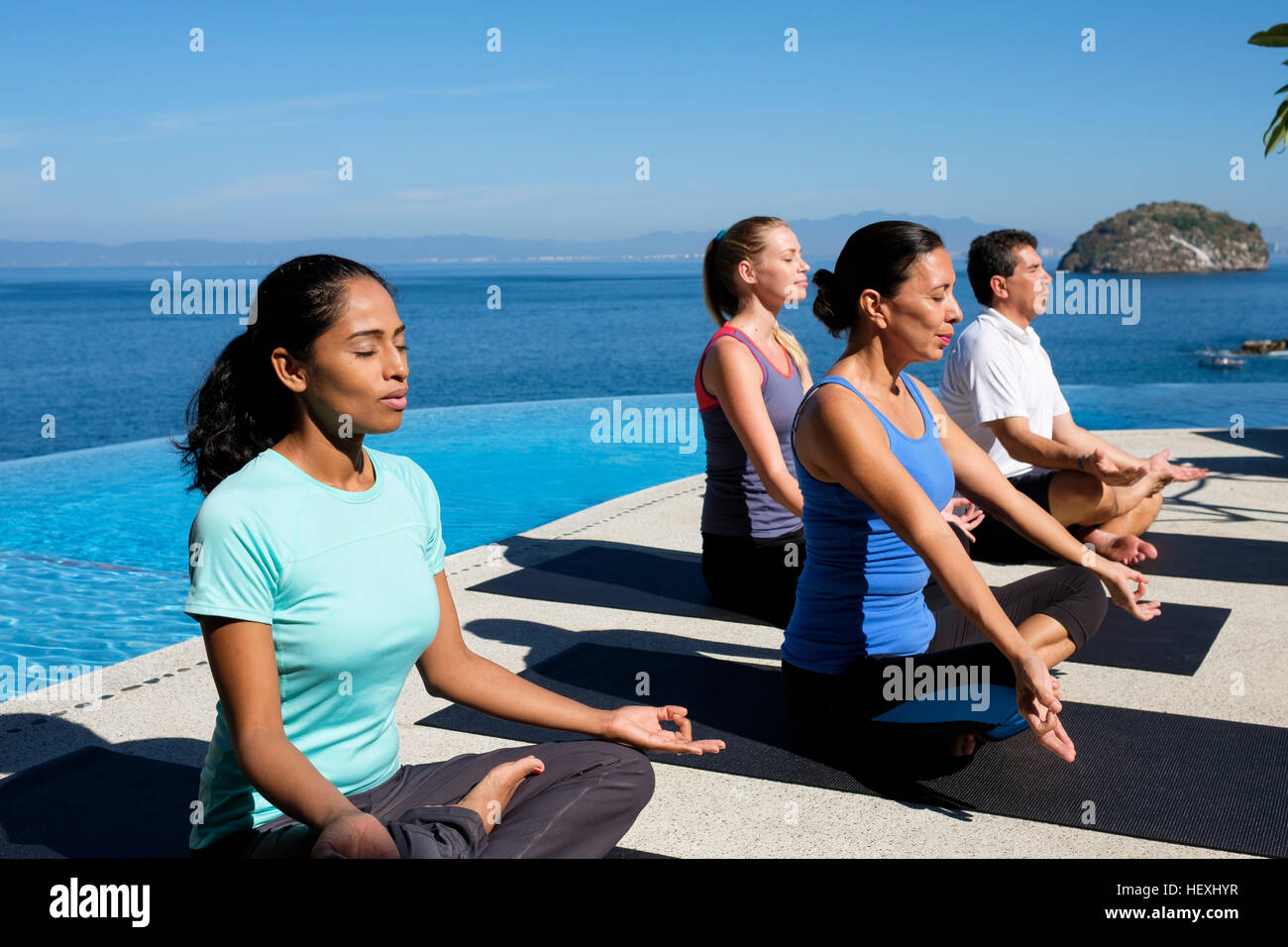 Yoga group exercising at ocean front resort Stock Photo - Alamy