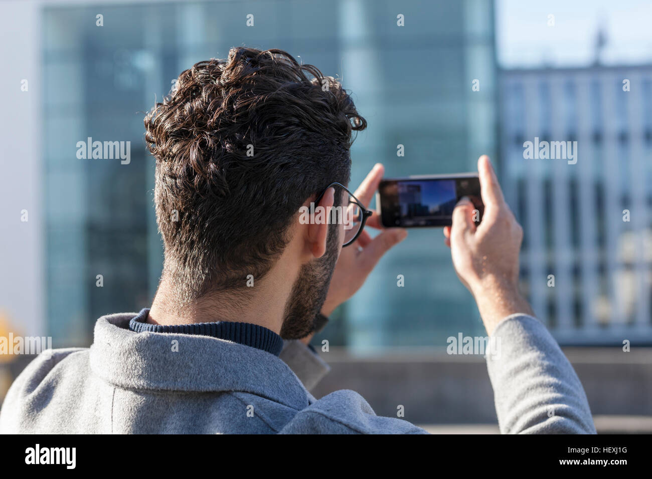 Back view of man taking picture with smartphone Stock Photo - Alamy