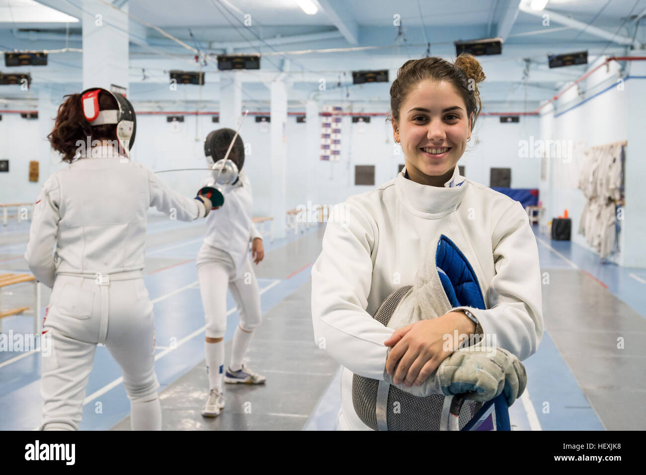 Smiling female fencer with fencing match in the background Stock Photo ...