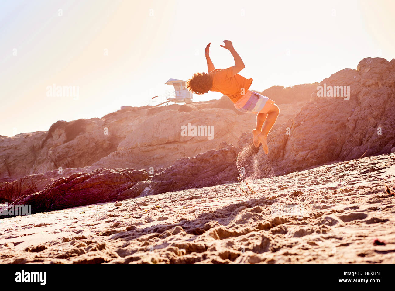 Young man on the beach doing a somersault Stock Photo - Alamy