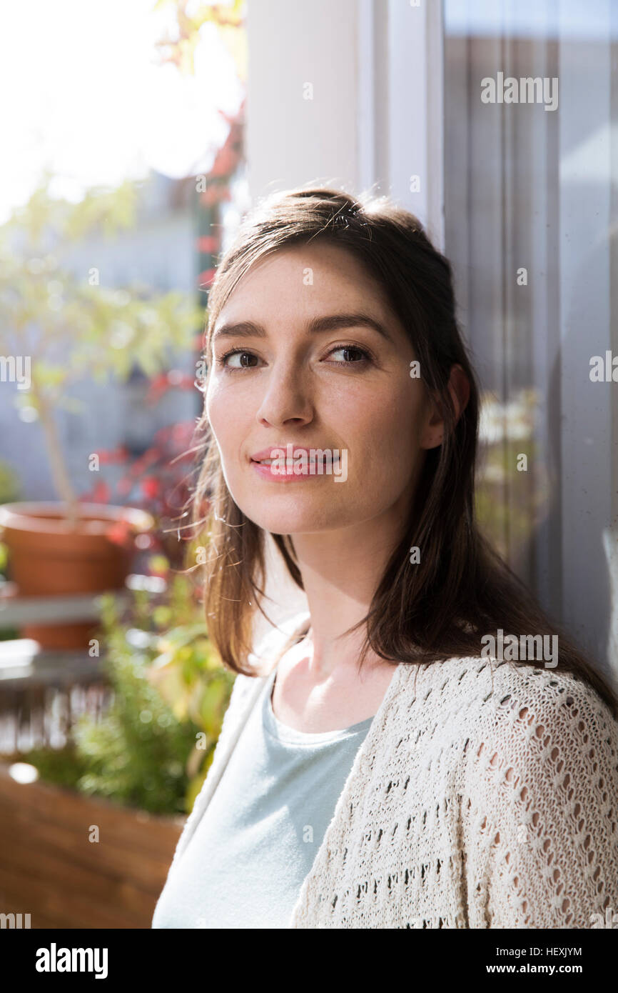 Portrait of smiling woman at the window Stock Photo - Alamy