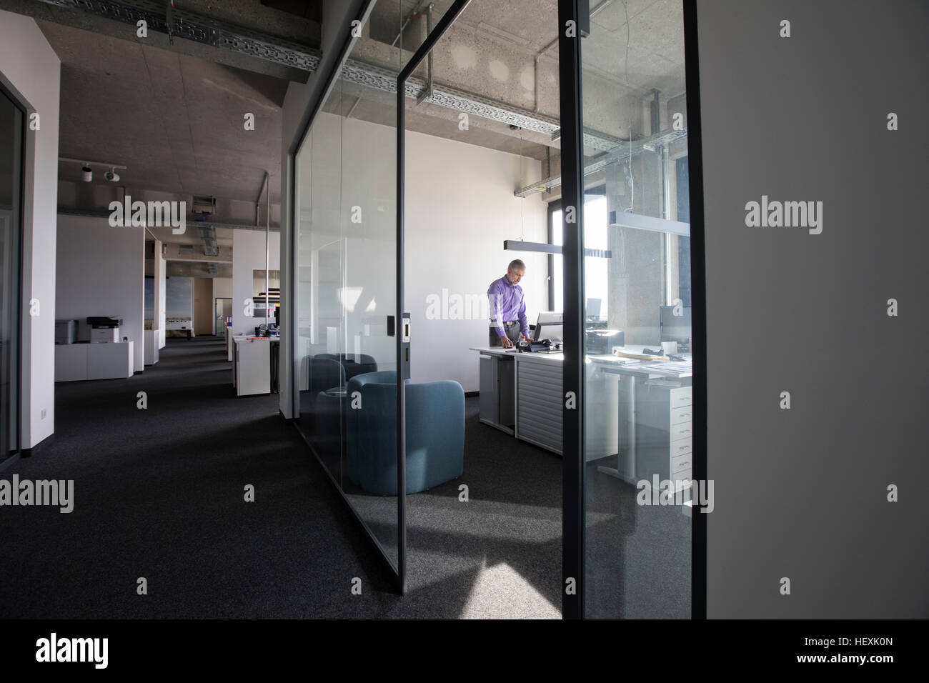 Businessman working alone in office Stock Photo - Alamy