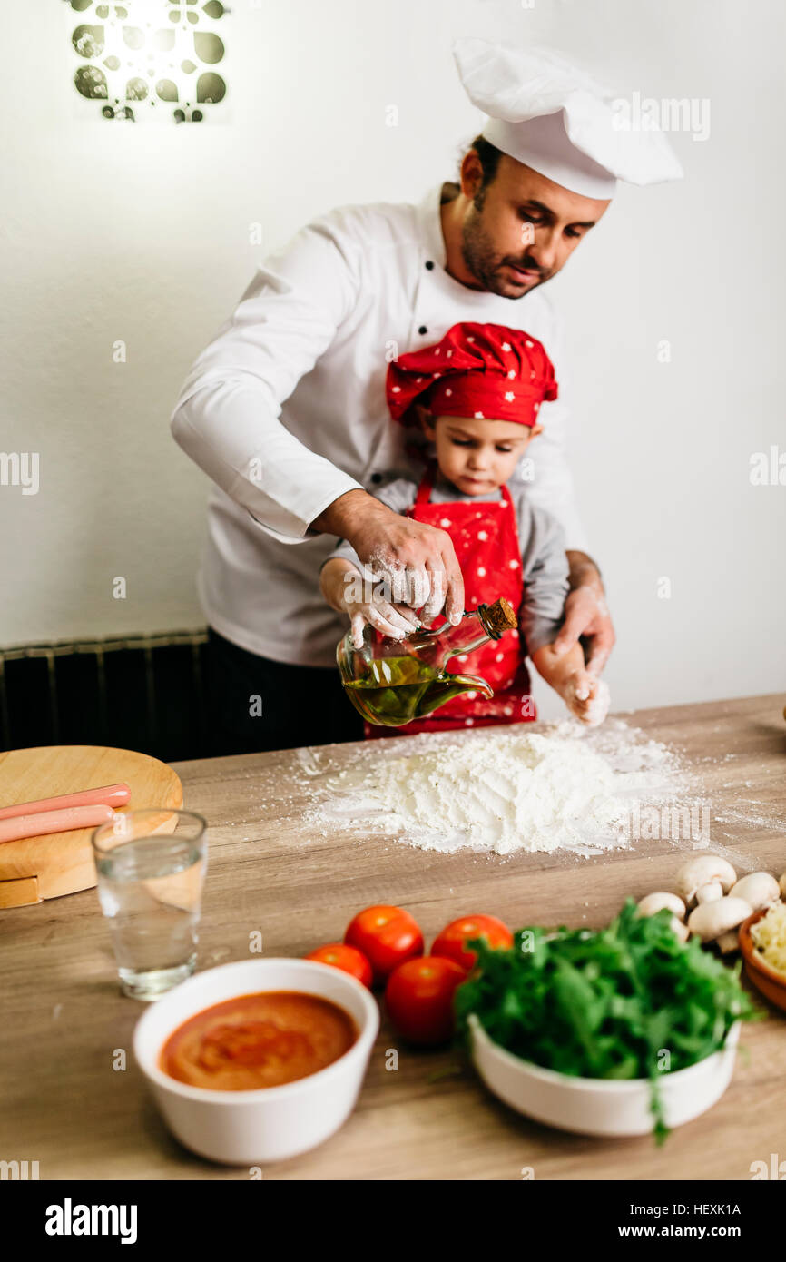Father and son preparing pizza together Stock Photo - Alamy