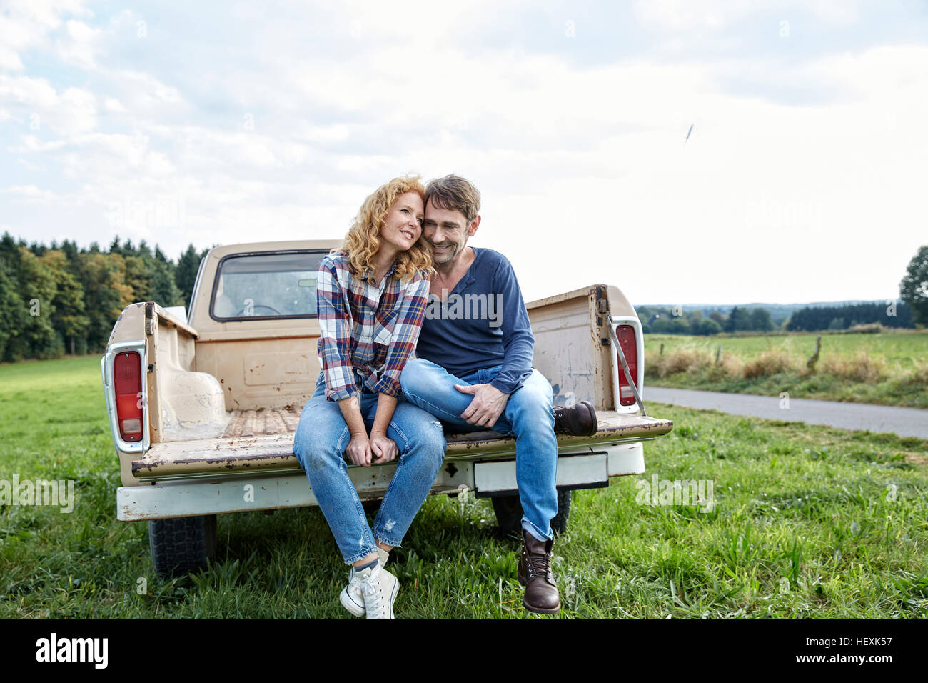 Couple sitting on pick up truck Stock Photo - Alamy