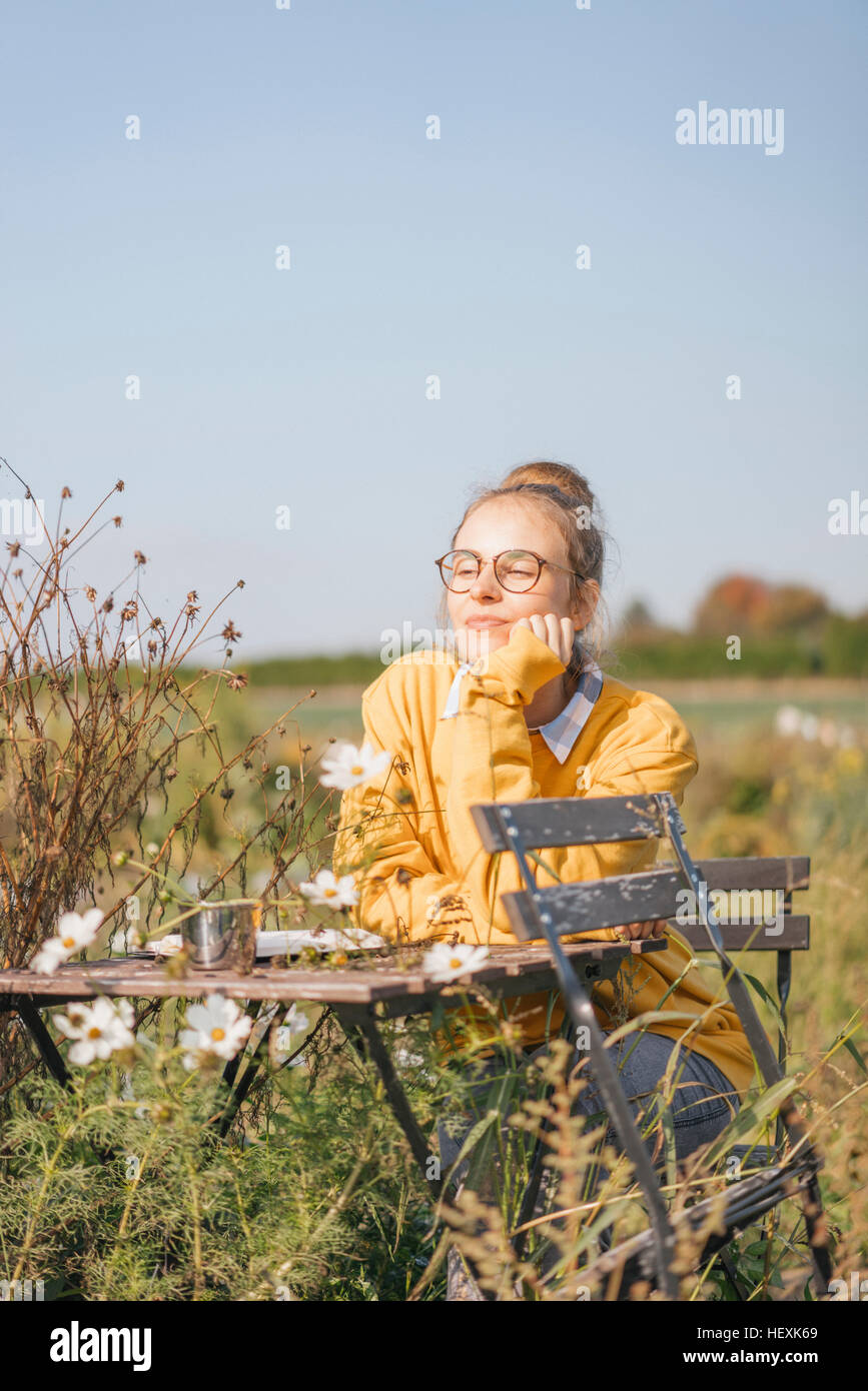 Young woman relaxing in cottage garden Stock Photo - Alamy