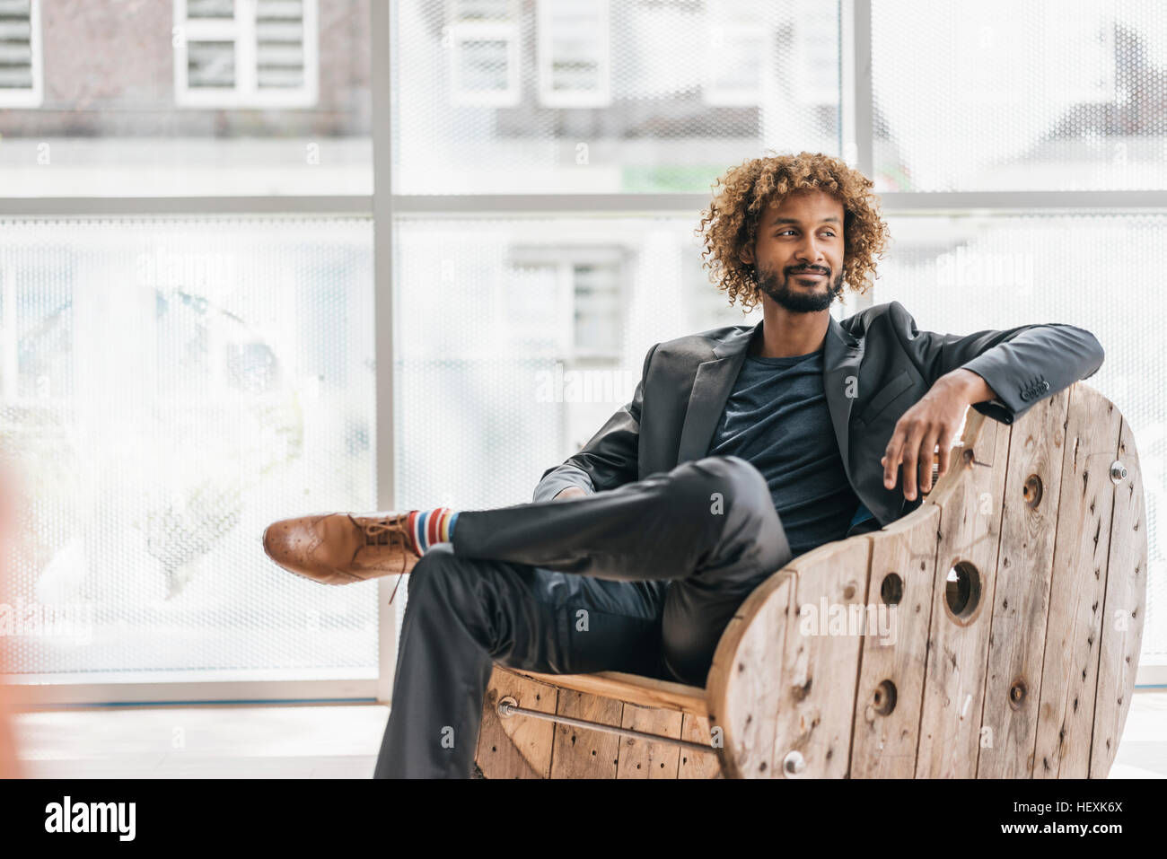 Young businessman sitting in wooden rocking chair Stock Photo - Alamy