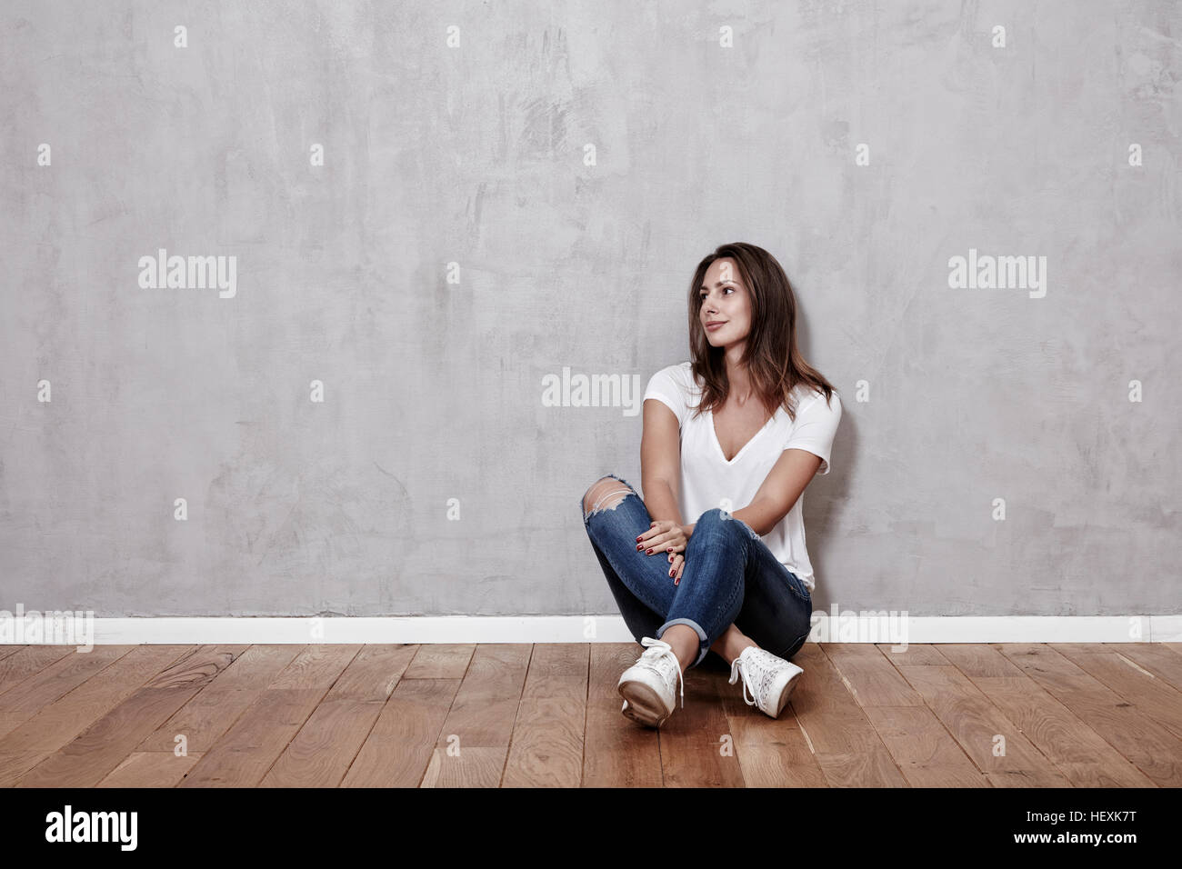 Young woman sitting on the floor Stock Photo - Alamy