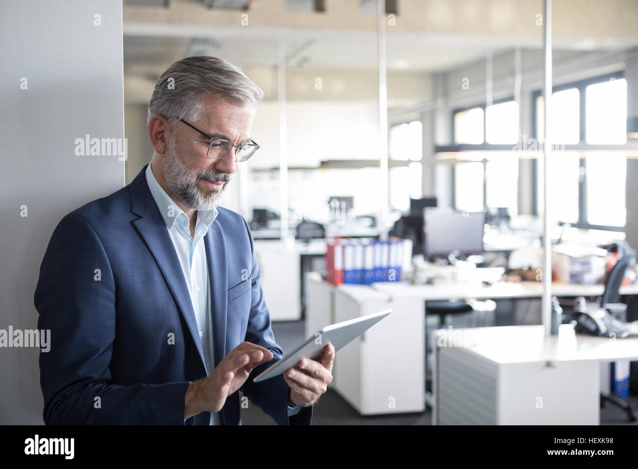 Businessman in office using tablet Stock Photo - Alamy