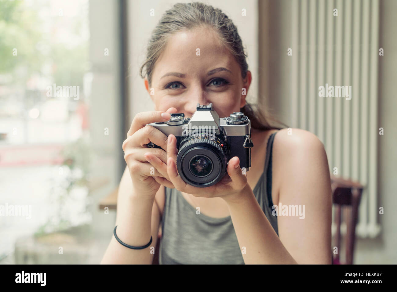 Portrait of smiling young woman hoding a camera Stock Photo - Alamy