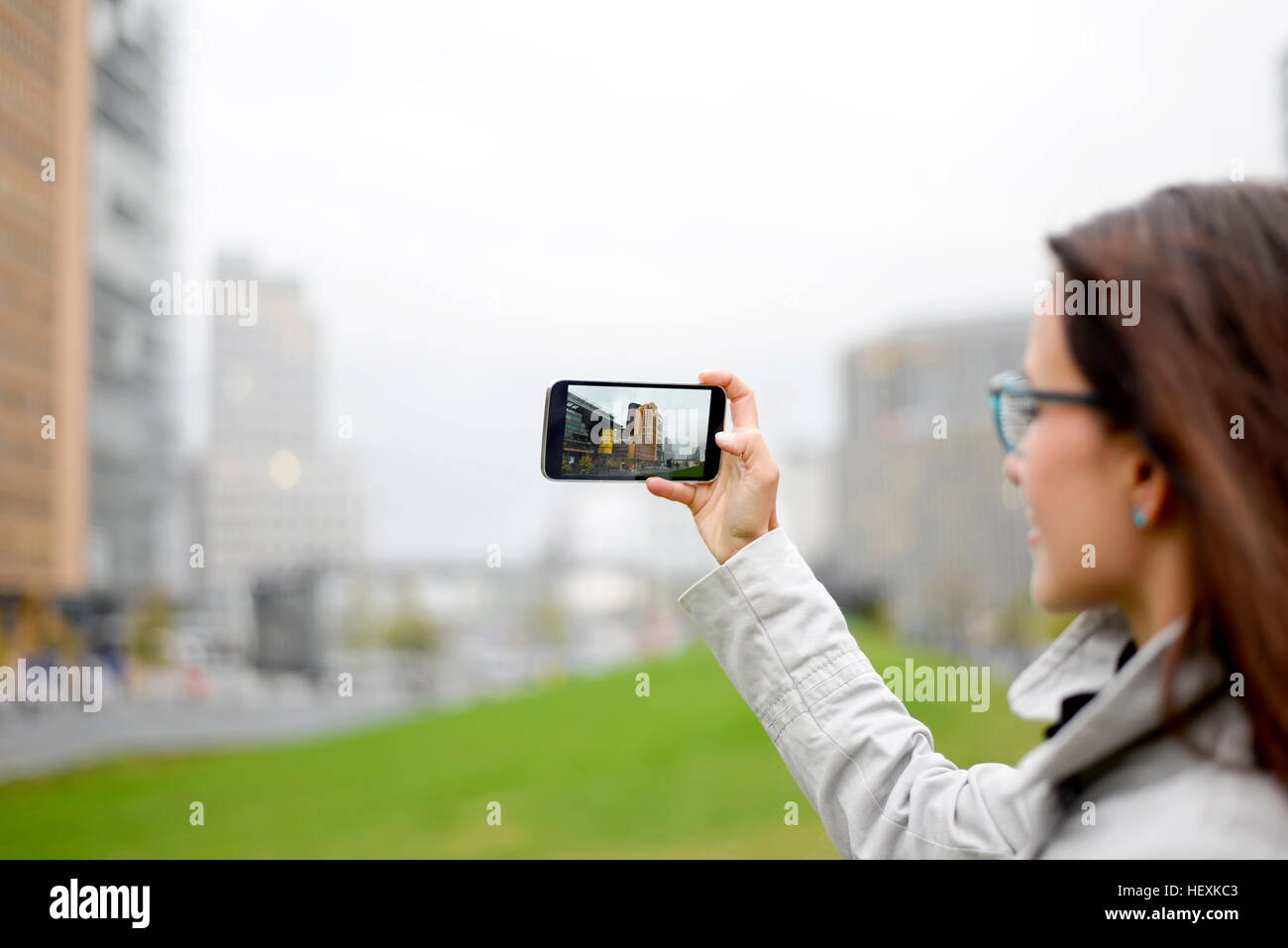 Germany, Berlin, woman taking picture with cell phone at Potsdamer ...