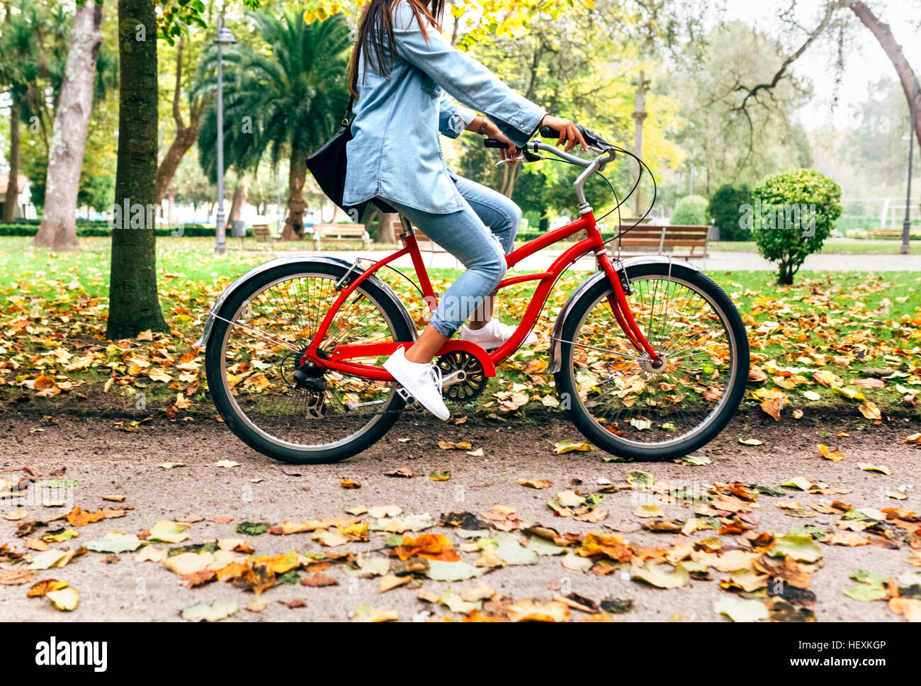 Young woman riding a bike in a park Stock Photo - Alamy