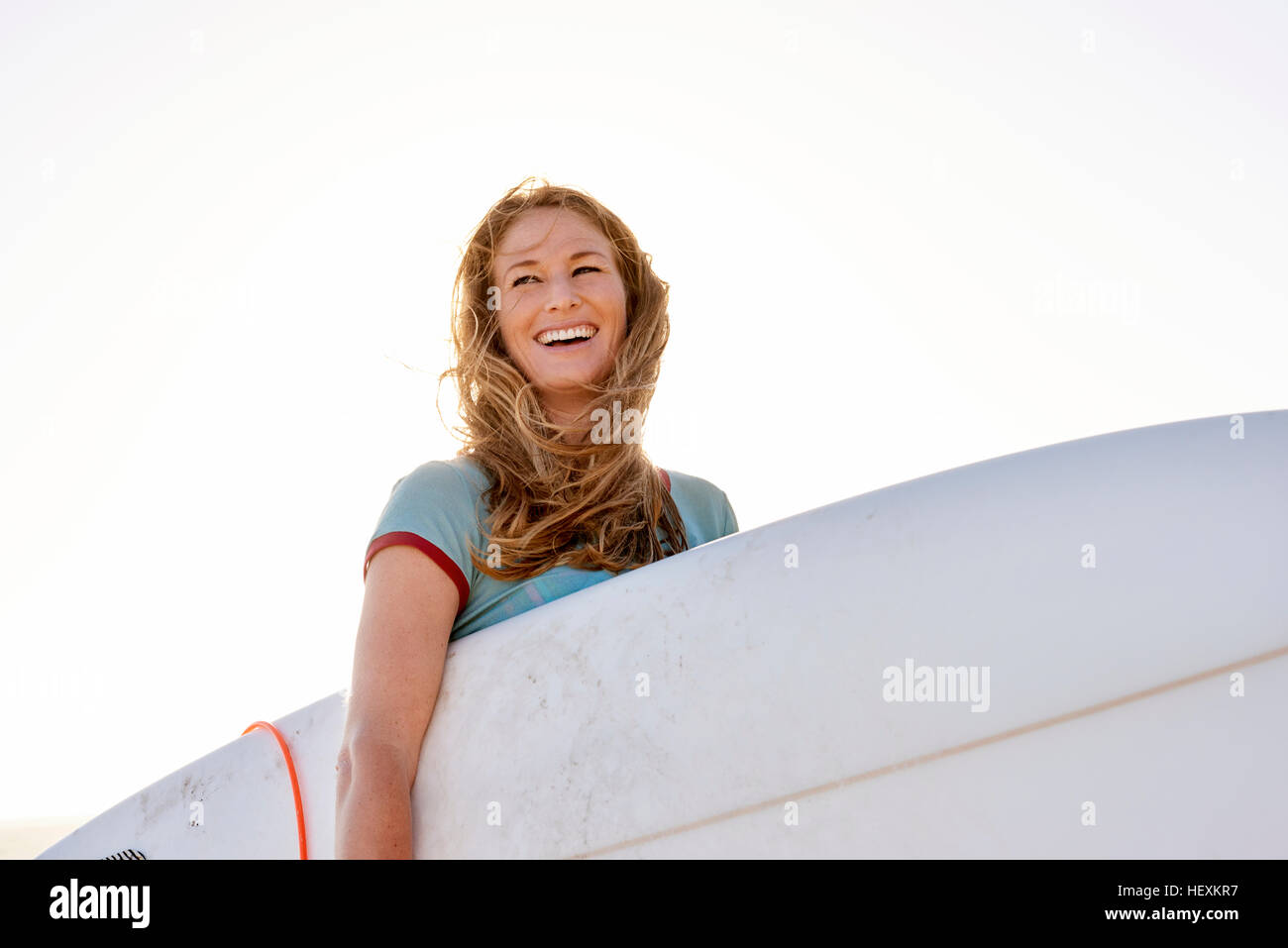 Happy woman carrying surfboard hi-res stock photography and images - Alamy