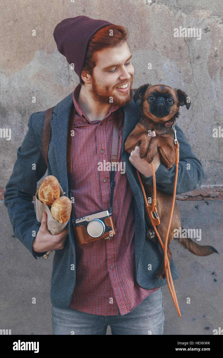 Smiling young man holding dog Stock Photo - Alamy