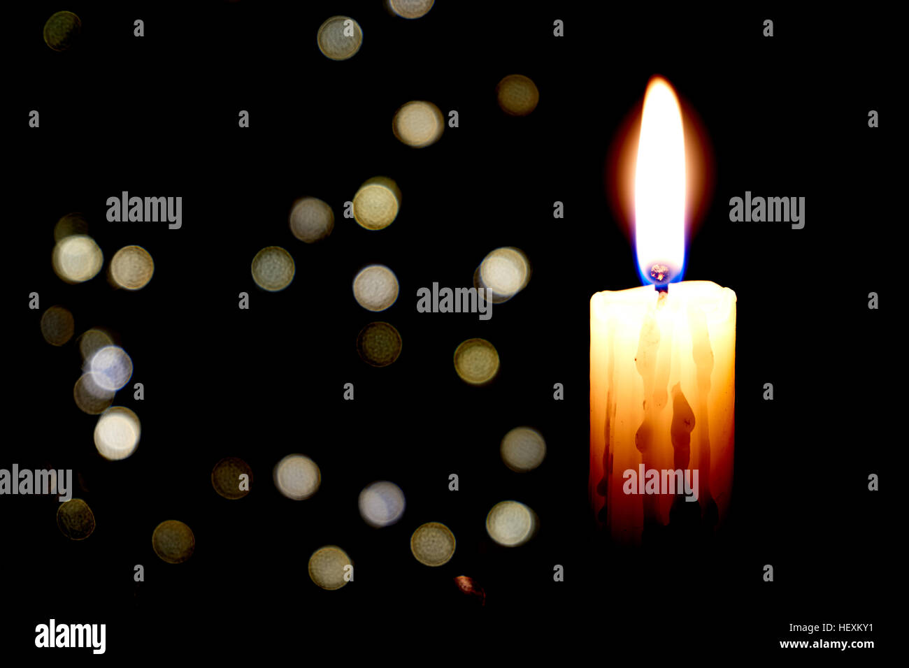 Lone candle in front of lights Stock Photo - Alamy