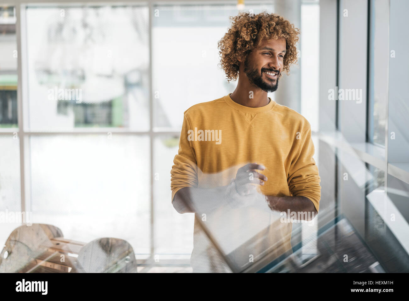 Young man looking out of window Stock Photo - Alamy