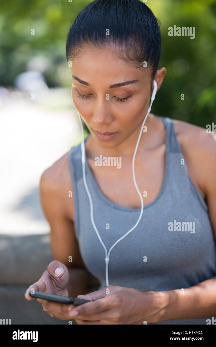 Female athlete listening to music with smartphone Stock Photo - Alamy