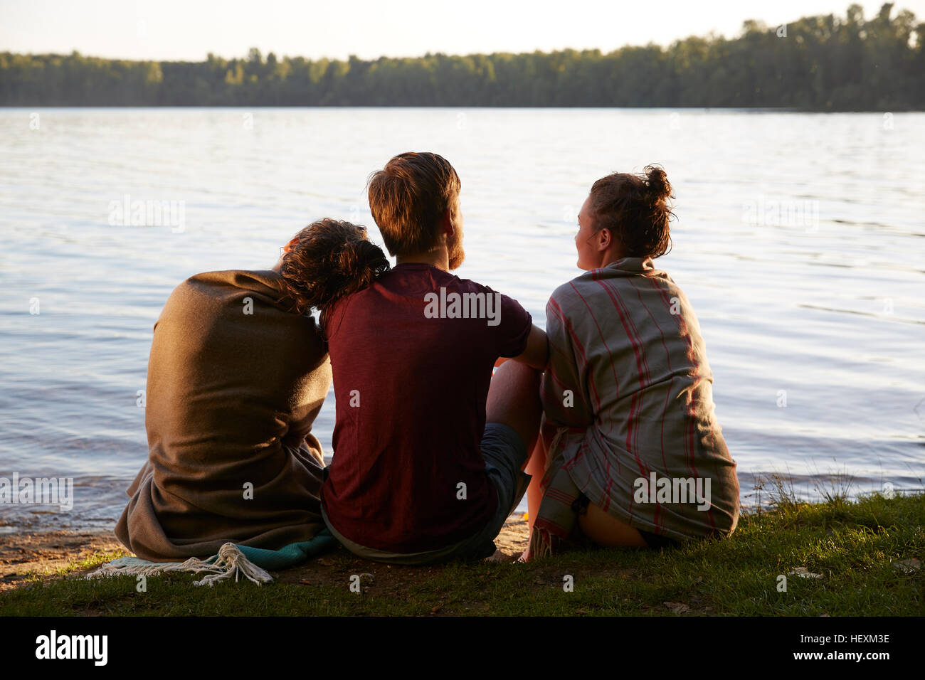 Friends sitting at a lake Stock Photo - Alamy