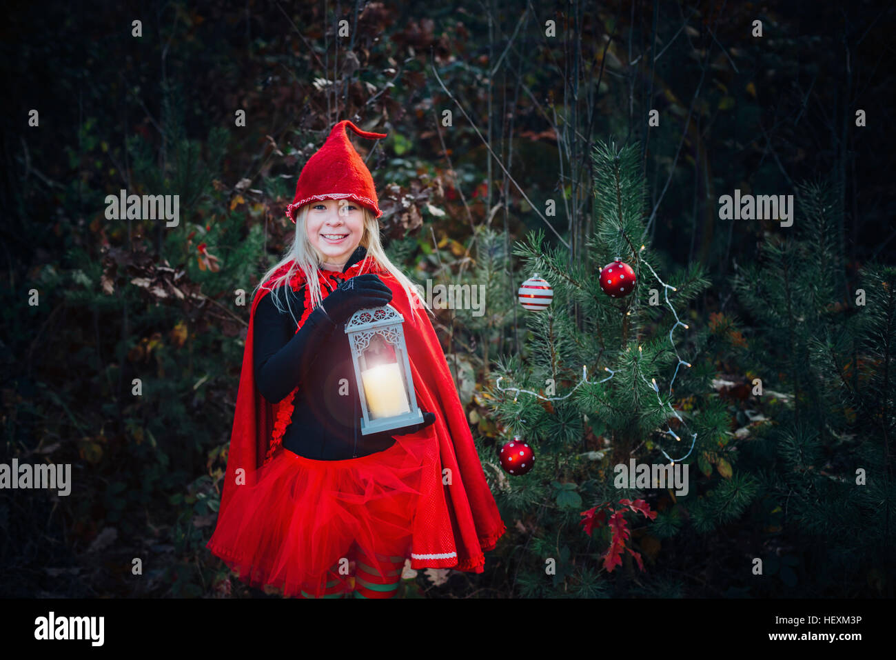 Little imp in forest holding lantern Stock Photo - Alamy