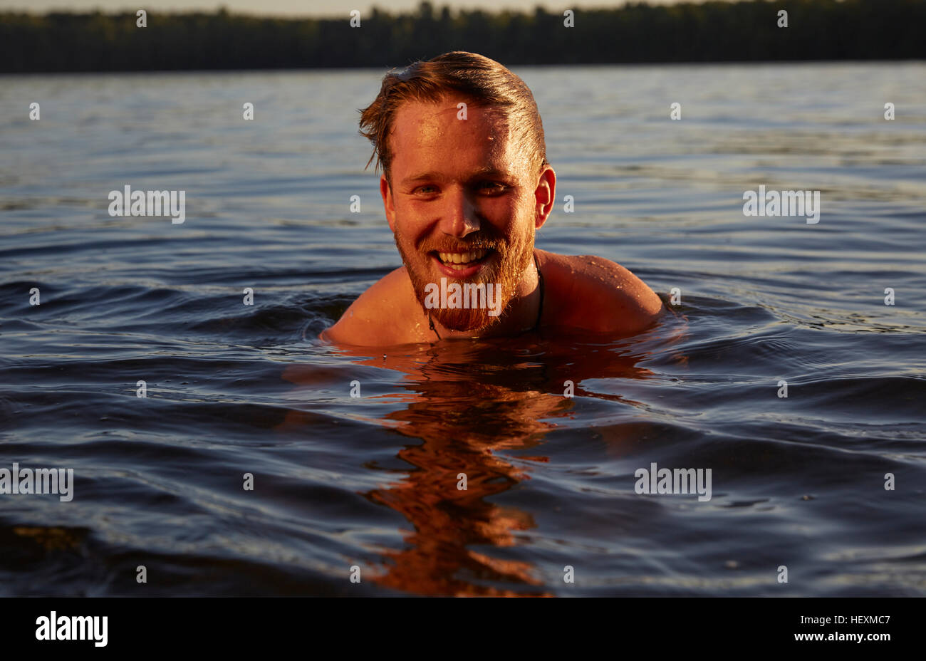 Happy young man in a lake Stock Photo - Alamy