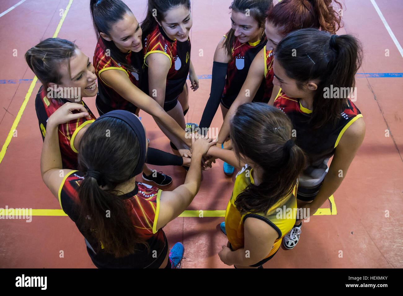 Female volleyball team huddling and stacking hands Stock Photo - Alamy
