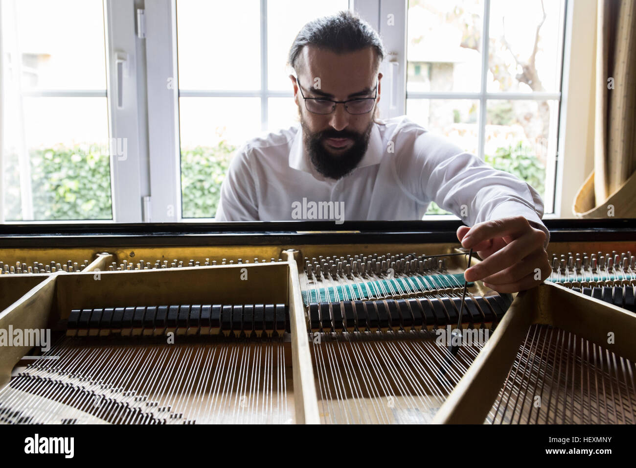 Piano tuner tuning grand piano Stock Photo - Alamy