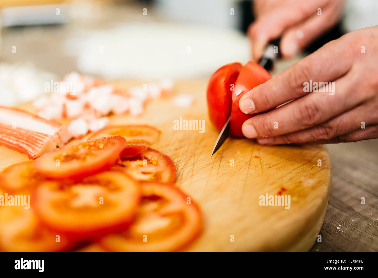 Slicing tomatoes in kitchen Stock Photo - Alamy